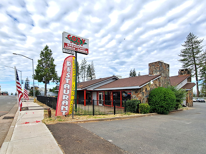 The brick exterior of Cozy Diner welcomes hungry travelers like an old friend, its red trim and rustic charm promising comfort food salvation in Paradise.