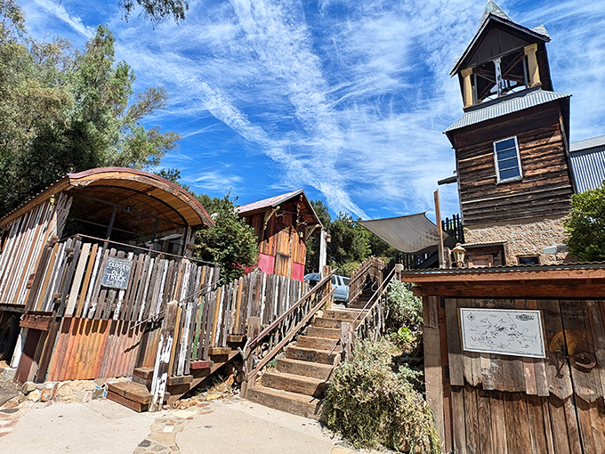 The Old Place stands defiant against time, its weathered wood and rustic tower beckoning hungry travelers like a frontier outpost for modern appetites.
