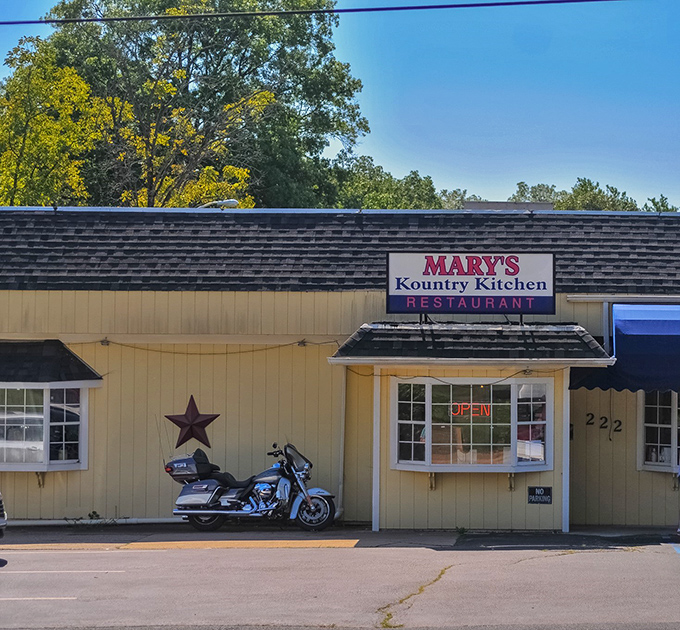 The unassuming yellow exterior of Mary's Kountry Kitchen, complete with rustic star and motorcycle, promises authentic comfort without pretension.