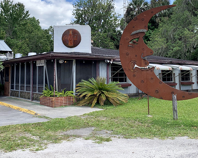 The unassuming exterior of The Yearling Restaurant stands as Florida's literary landmark turned culinary destination, Spanish moss and pickup trucks included.