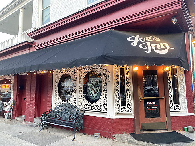 The iconic red brick exterior of Joe's Inn beckons like an old friend, complete with charming black awning and ornate window frames that whisper "come on in."