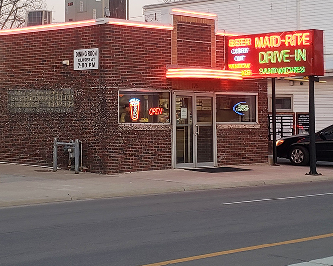 The neon glow of Maid-Rite's vintage sign beckons like a lighthouse for hungry travelers seeking comfort food salvation in Greenville.