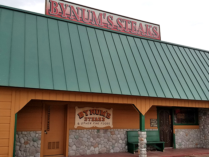 The iconic green roof and stone facade of Bynum's Steakhouse stands as a beacon for hungry travelers. No fancy frills needed when what's inside is this good.