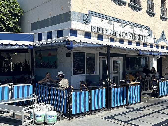 The blue and white striped awnings aren't just charming—they're practically waving "come eat something delicious" in maritime flag code.