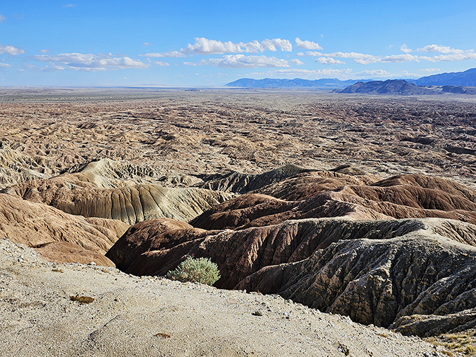 The open road beckons as motorcyclists cruise past rugged mountain terrain, where adventure awaits around every bend at Anza-Borrego's magnificent entrance.
