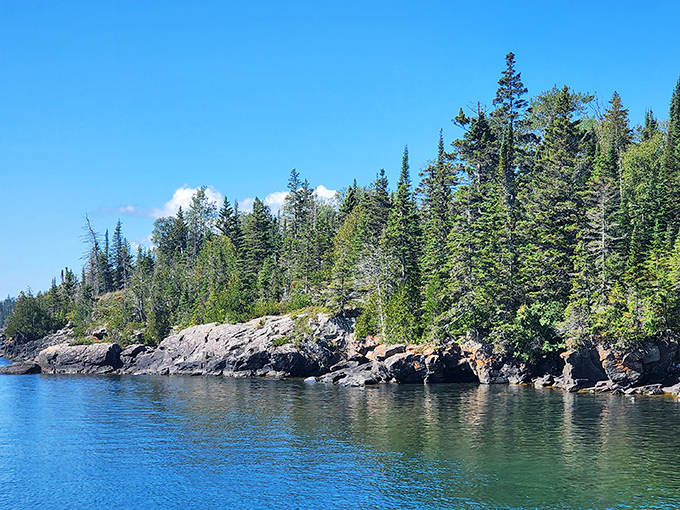 Nature's perfect postcard doesn't exi— Oh wait, it does! The pristine shoreline of Isle Royale where Lake Superior's crystal waters meet ancient bedrock and evergreen sentinels.