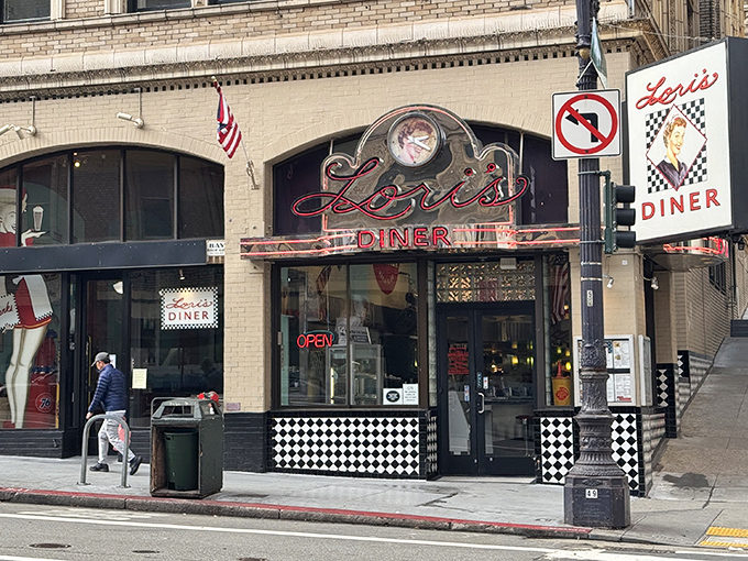 The neon promise of Lori's Diner glows against San Francisco's urban landscape, a beacon of retro comfort in a sea of modern hustle.