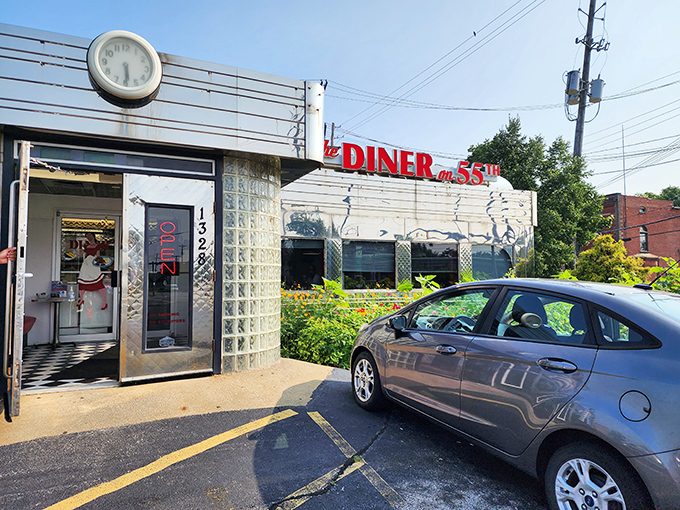 The gleaming stainless steel exterior of The Diner on 55th stands as a time capsule of Americana, complete with classic clock and red signage that beckons hungry travelers.