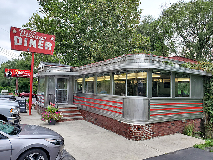 The classic red and silver exterior of Village Diner stands like a time machine in Milford, beckoning hungry travelers with its mid-century charm and promise of comfort food.