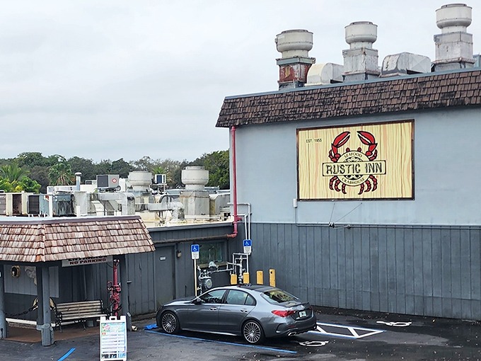 The iconic Rustic Inn Crabhouse exterior beckons seafood lovers with its weathered shingle roof and playful crab photo-op board. Florida dining at its unpretentious best.