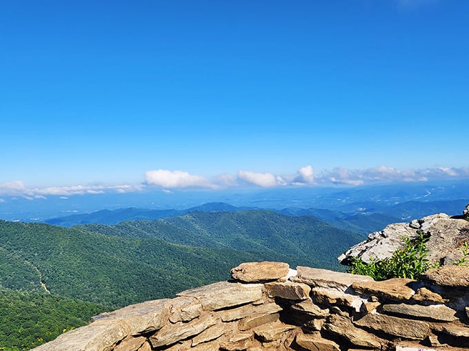 Layer upon layer of blue-tinged mountains stretch to the horizon, with nature's own stone wall providing the perfect foreground for your "I'm on top of the world" moment.