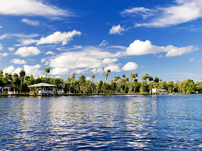 Where the sky meets the water in perfect Florida harmony. Palm trees stand like nature's welcome committee along this peaceful riverfront paradise.
