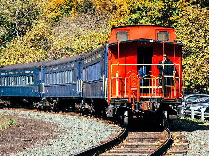 The iconic red caboose and blue coaches of the Lehigh Gorge Scenic Railway wind through autumn's paintbox&mdash;nature's own masterpiece on full display.