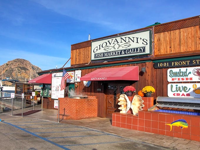 Giovanni's wooden exterior welcomes seafood pilgrims with the promise of oceanic treasures, while Morro Rock stands guard in the background like a culinary lighthouse.