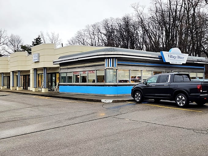 The classic blue-trimmed exterior of Village Diner stands like a time capsule of Americana, promising honest food without pretension.