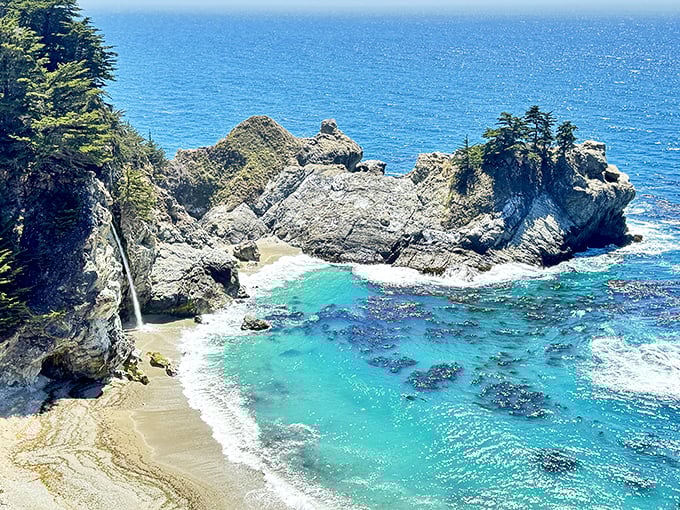 Nature's perfect postcard unfolds at McWay Cove, where turquoise waters meet golden sand beneath dramatic cliffs. This isn't Photoshop—it's just another Tuesday in Big Sur.