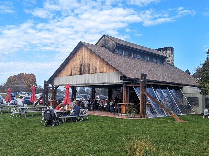 The rustic barn exterior of Sarah's Vineyard welcomes visitors with its weathered wood charm and inviting outdoor seating—Napa Valley spirit with heartland hospitality.