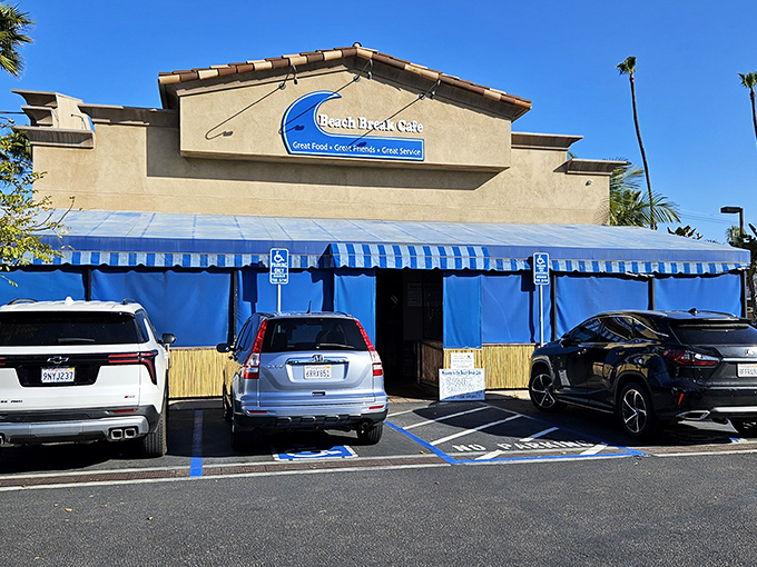 The blue-awninged beacon of breakfast bliss beckons hungry beachgoers with its promise of coastal comfort food and surfside charm.