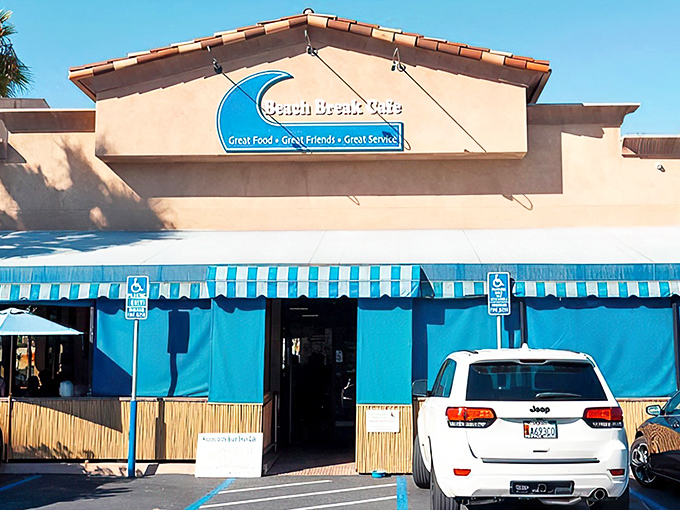 Beach Break Cafe welcomes you with its iconic blue awnings and surf-inspired signage, promising great food before you even step inside.