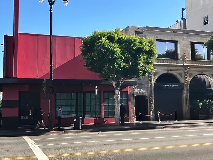 The purple neon "Beetle House" sign glows against stone walls like a gothic invitation. Tim Burton's spirit beckons from this architectural oddity on the LA streets.