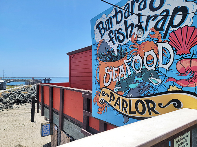 The iconic red exterior of Barbara's Fishtrap stands like a colorful sentinel against the Half Moon Bay coastline, promising seafood treasures within.