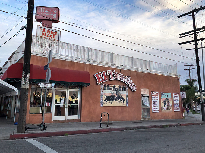 The unassuming salmon-pink exterior of El Taurino might not scream "food destination," but that bullfighting mural is your first clue to culinary greatness within.