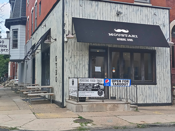 The unassuming storefront with its weathered wood and dapper mustache logo promises authentic Greek delights inside this Philadelphia corner treasure.
