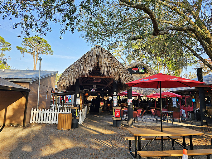 The thatched-roof entrance to Cherry Pocket beckons like a tropical mirage, promising cold drinks and hot seafood under the Florida sun.