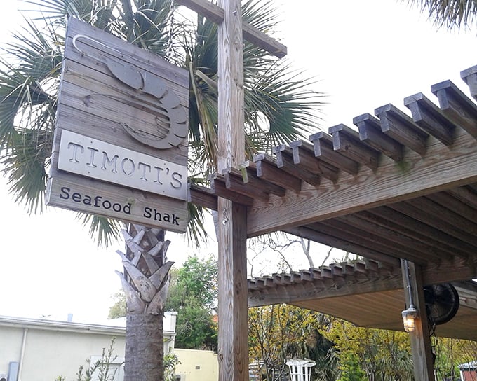 The unassuming exterior of Timoti's Seafood Shak beckons with rustic charm. That corrugated metal and wooden menu board? Pure Florida coastal casual.