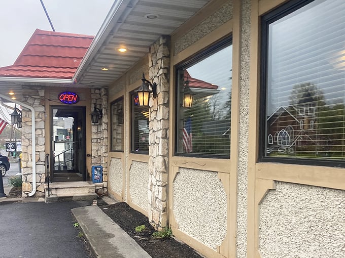 The stone facade and glowing "OPEN" sign beckon like an old friend. This unassuming exterior hides breakfast treasures that locals have cherished for generations.