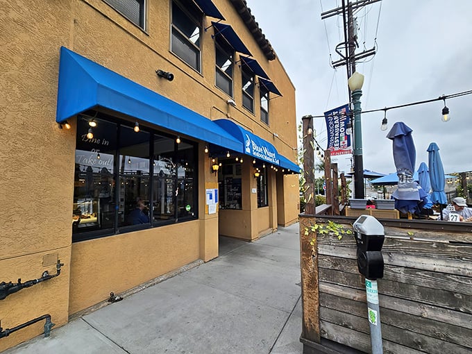 The iconic blue awning beckons seafood lovers like a maritime lighthouse. Simple stucco exterior hides culinary treasures that have San Diegans lining up daily.
