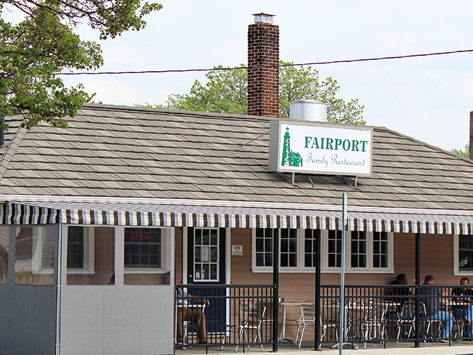 The unassuming exterior of Fairport Family Restaurant, where culinary magic happens behind that modest striped awning and simple sign.