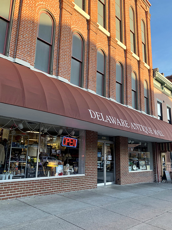 The iconic burgundy awning of Delaware Antique Mall beckons treasure hunters into this historic brick building, where the past awaits rediscovery.