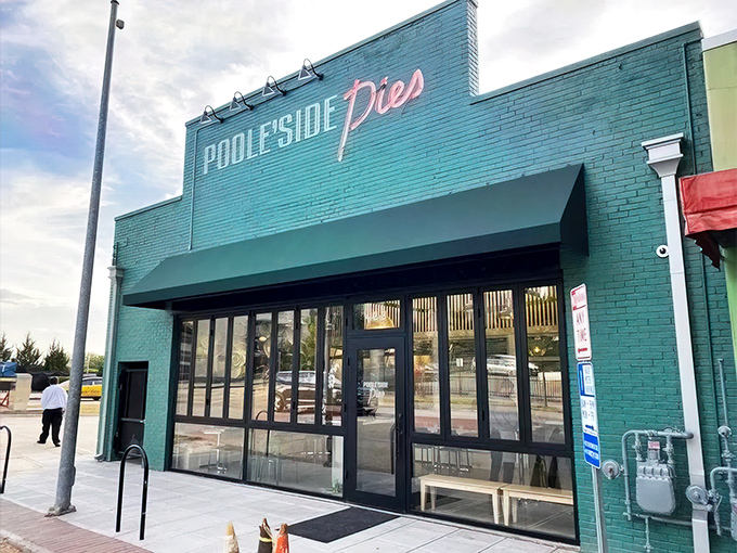The turquoise facade of Pooleside Pies glows like a beacon for hungry souls, promising comfort in neon-lit form.