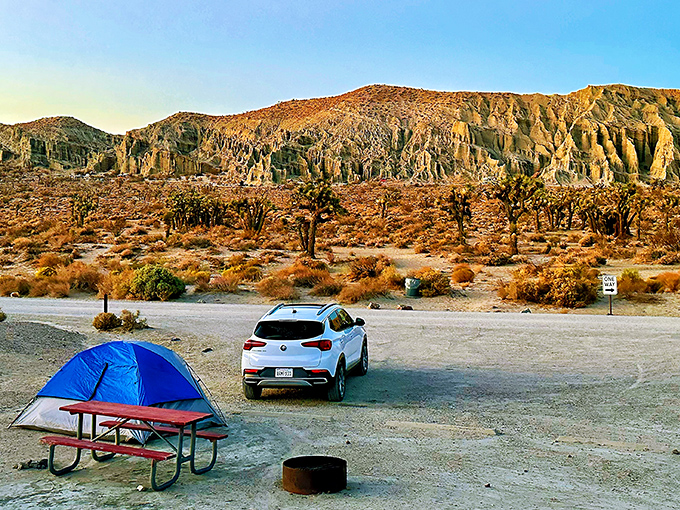A perfect California campsite: blue tent, picnic table, and nature's most spectacular backdrop. Mars-like formations meet Joshua trees at sunset.