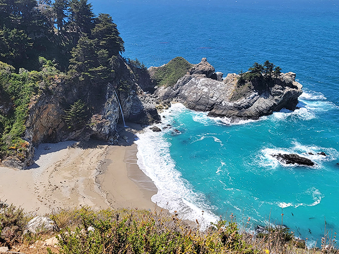 Nature's perfect postcard unfolds at McWay Cove, where turquoise waters meet golden sand beneath dramatic cliffs. This isn't Photoshop&mdash;it's just another Tuesday in Big Sur.