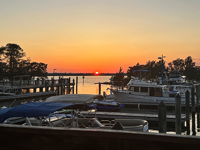 A fiery sunset bathes Carolina Beach State Park's marina in golden light, where day's end brings peaceful closure to river adventures.