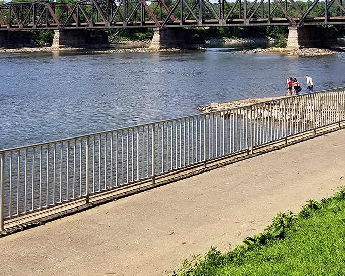 Where two mighty rivers meet, creating nature's perfect confluence. The historic railroad bridge stands as a silent sentinel to countless sunsets and fishing tales. 