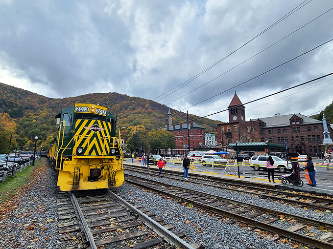 The bright yellow and green locomotive stands like a cheerful sentinel against autumn's golden canvas, promising adventures that smartphones simply can't capture.