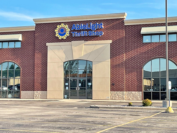 The brick facade of AbleLight Thrift Shop stands proudly in Appleton, its cheerful blue and yellow logo promising treasure hunters a day of delightful discoveries.