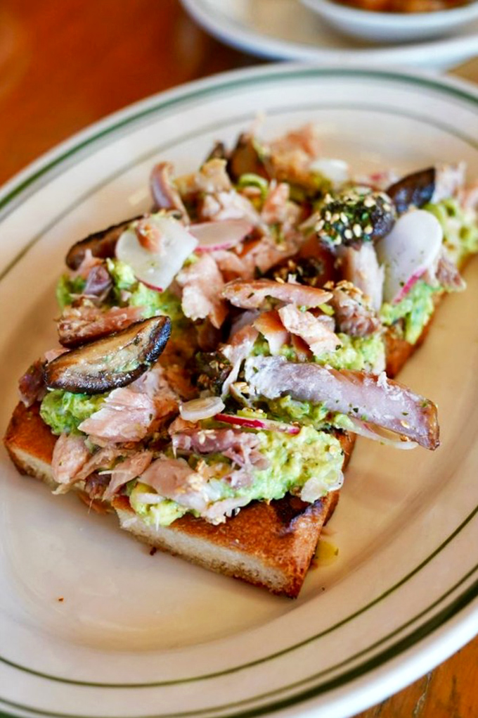 Avocado toast gets the seafood treatment with delicate fish, mushrooms, and enough green goodness to make California proud.