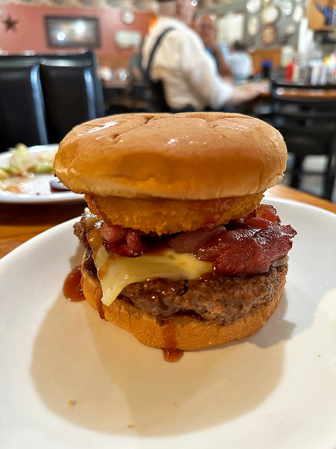 Not all heroes wear capes&mdash;some wear bacon, cheese, and what appears to be an onion ring crown. This burger doesn't just satisfy hunger&mdash;it conquers it.