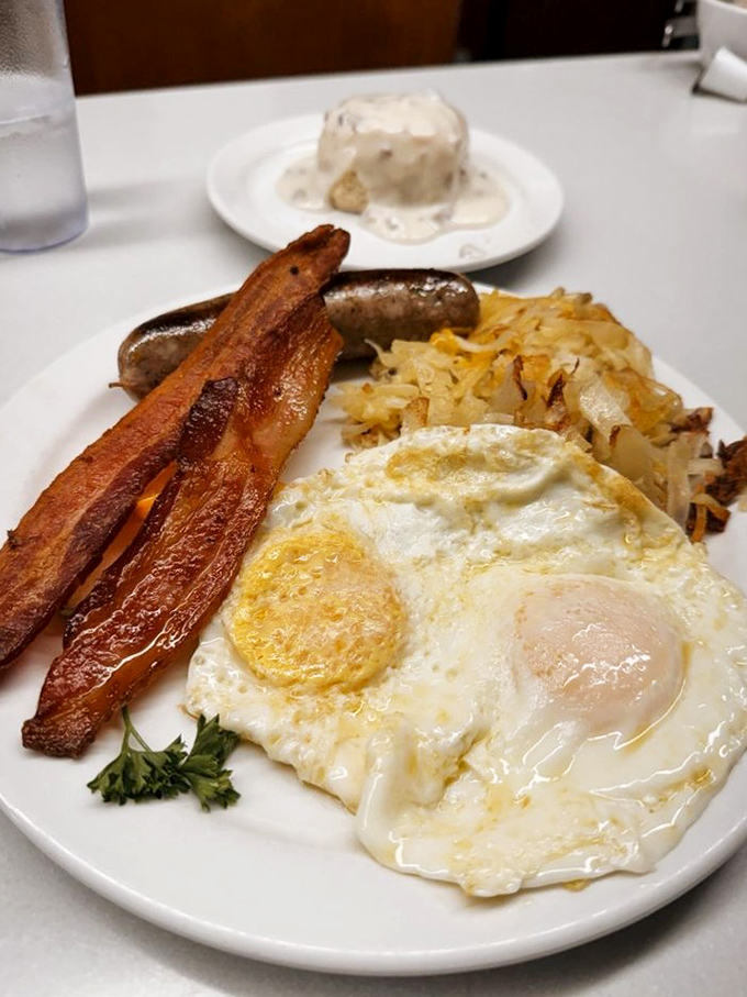 Bacon cooked to that magical point between chewy and crisp, alongside sunny-side-up eggs that practically radiate morning happiness.