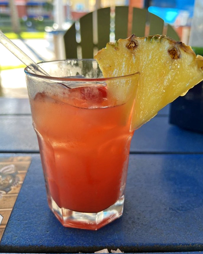 This tropical drink arrives dressed for a luau, complete with a pineapple hat that screams "vacation mode activated."