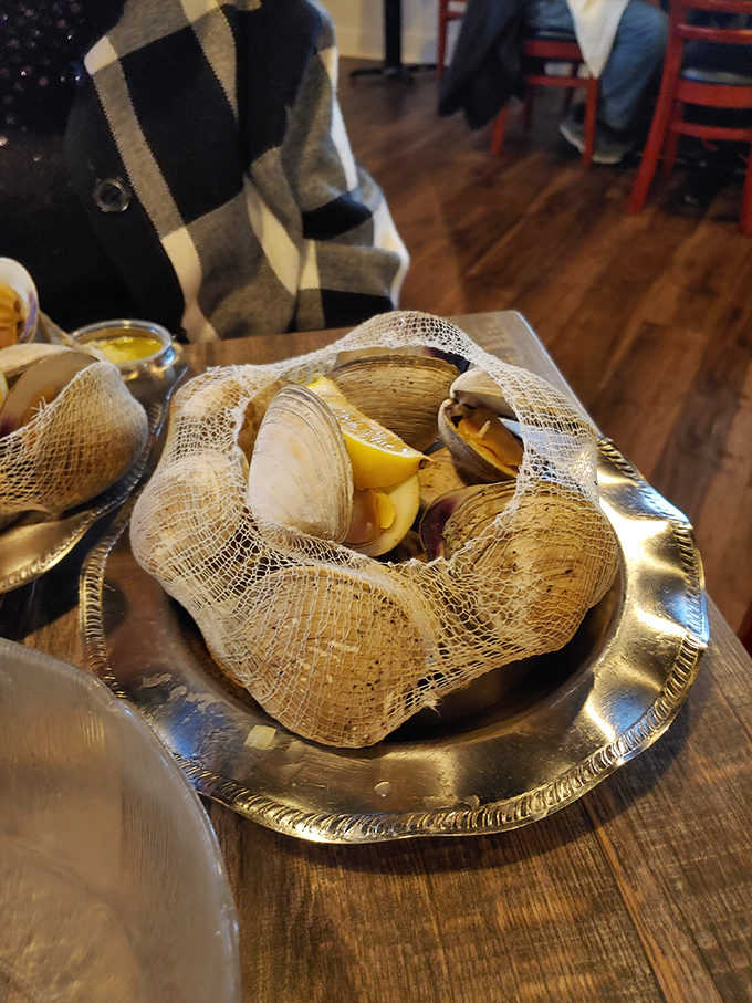 Baked clams in their mesh presentation bag &ndash; because even shellfish deserve to make a dramatic, Instagram-worthy entrance here.