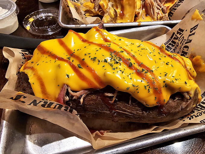 A loaded baked potato wearing a yellow cheese blanket striped with sauce&mdash;comfort food that's dressed for a night out on the town.