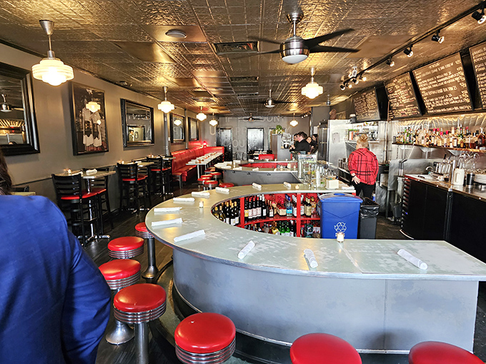 Red banquettes and a horseshoe counter invite lingering conversations where strangers become friends over shared plates and wine.