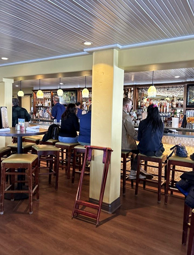 A bar where the bottles gleam like treasures and the stools practically whisper, "Stay for just one more ocean sunset."