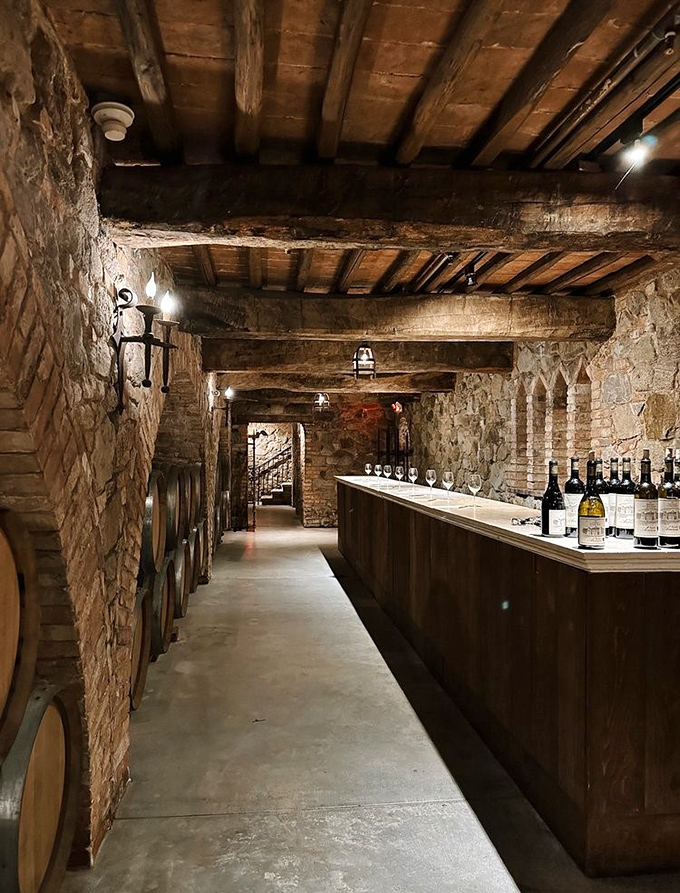 Stone arches frame this underground tasting bar where wine bottles stand like soldiers awaiting their call to delicious duty.