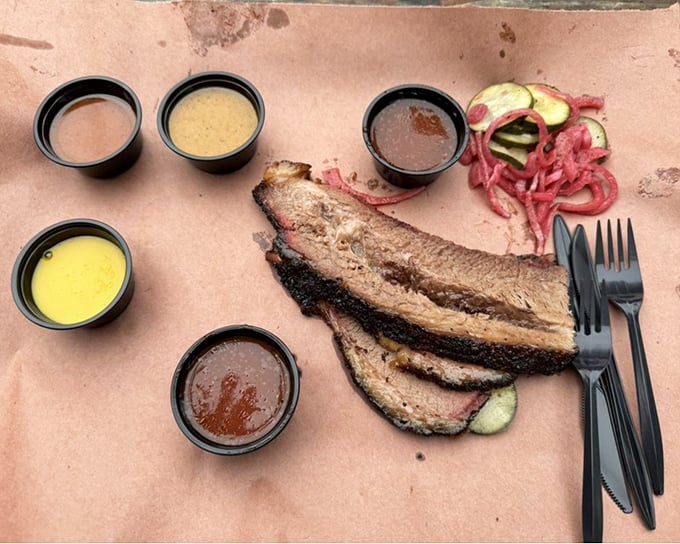 Brisket so tender it practically surrenders to your fork. Those sauce cups are standing by like eager backup dancers.